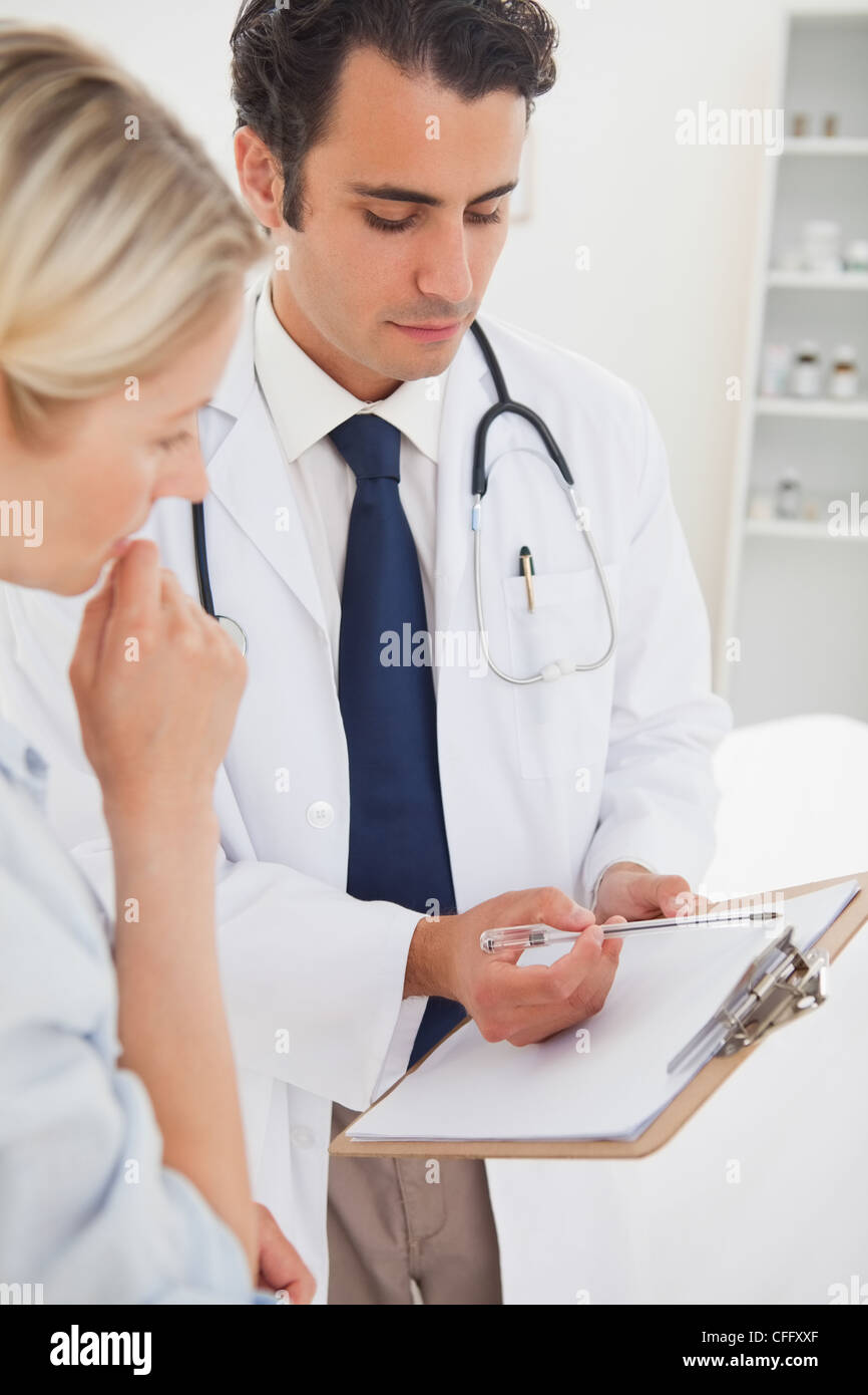 Doctor and his patient looking at clipboard together Stock Photo - Alamy