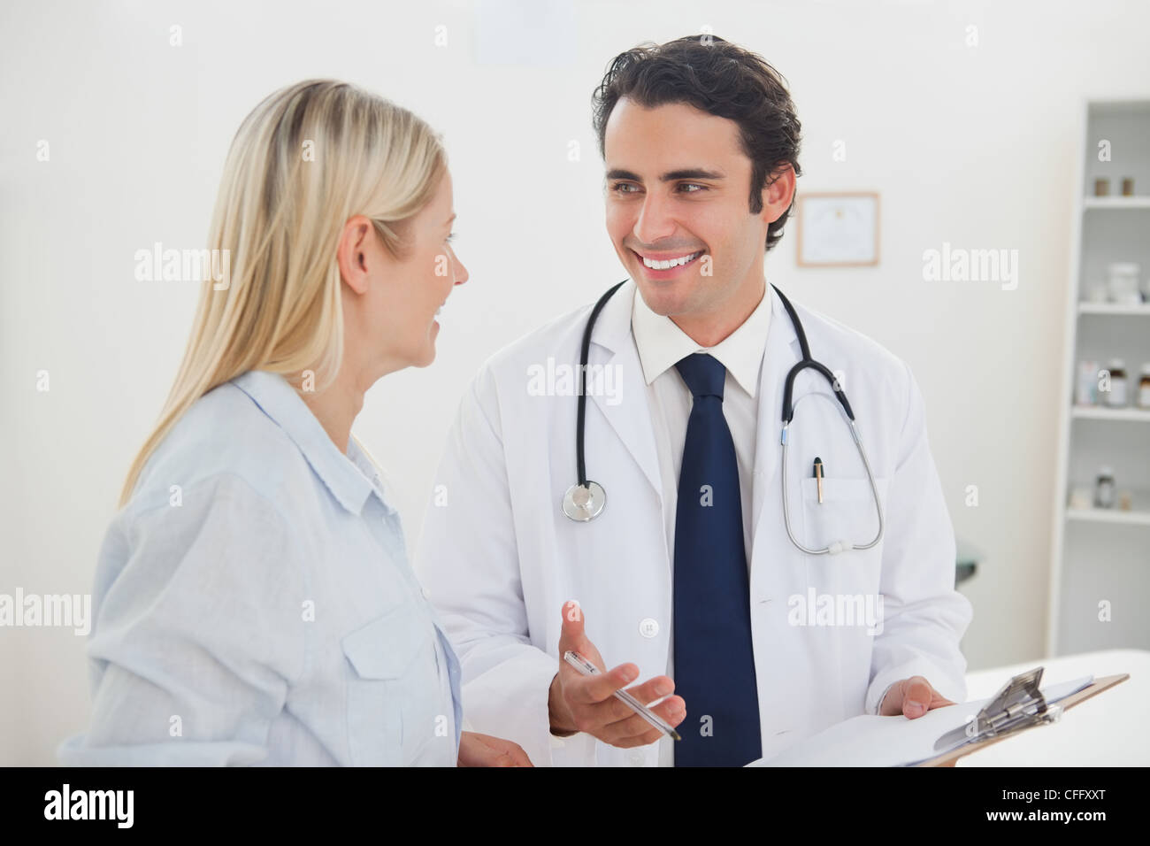 Smiling doctor talking with patient Stock Photo - Alamy