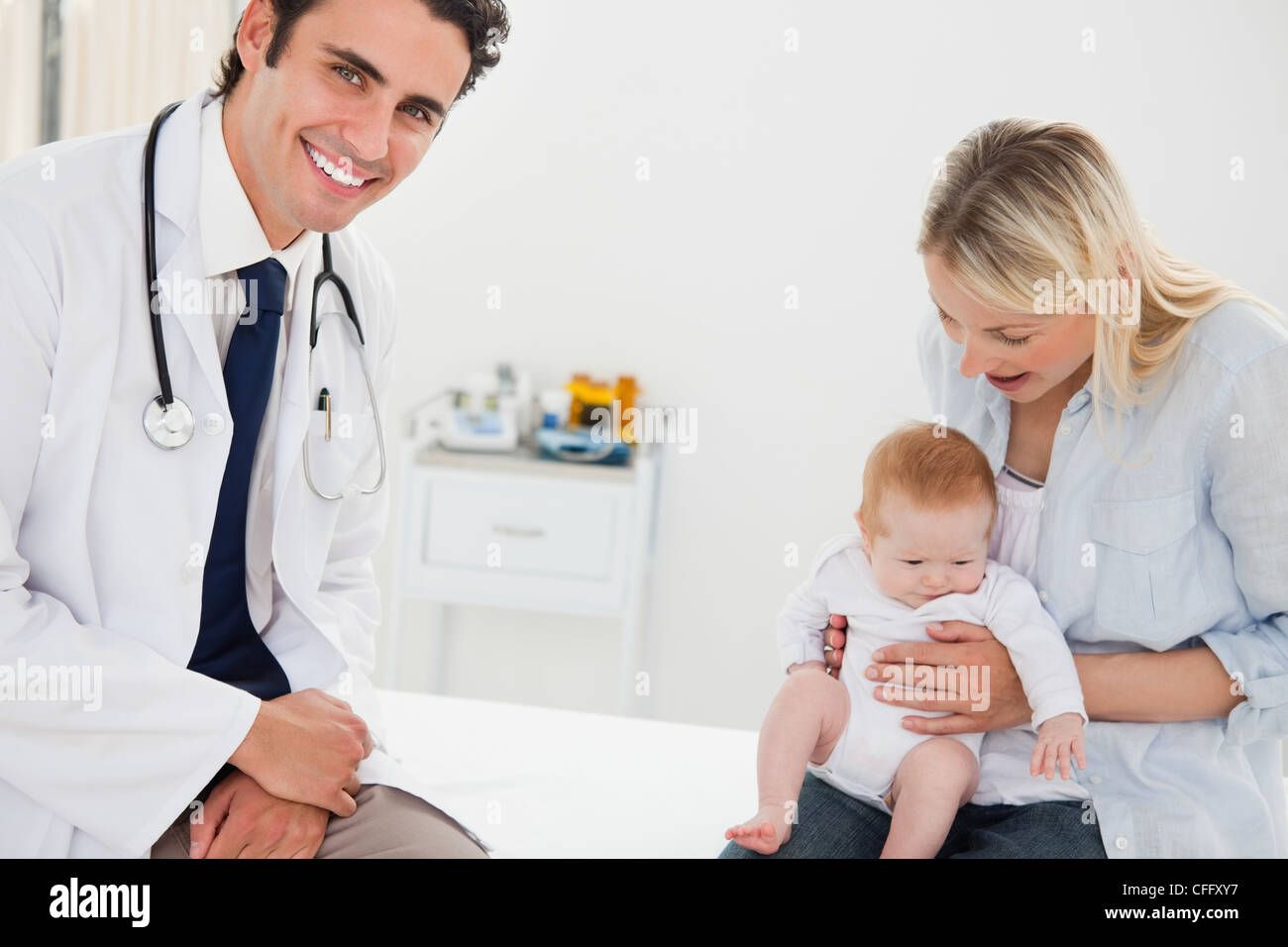 Smiling doctor with a mother and her baby Stock Photo - Alamy