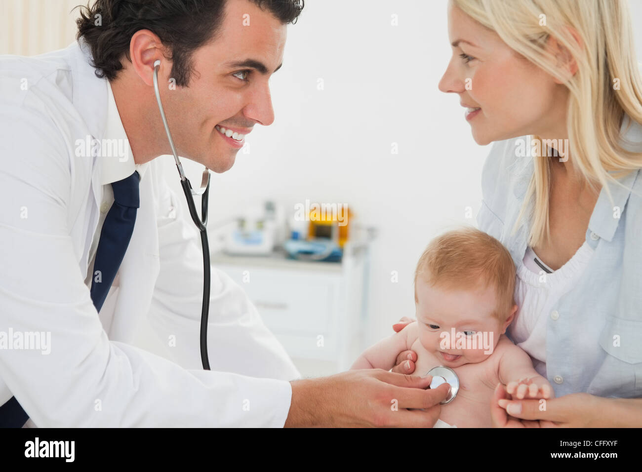 Smiling doctor taking baby's heart beat Stock Photo - Alamy