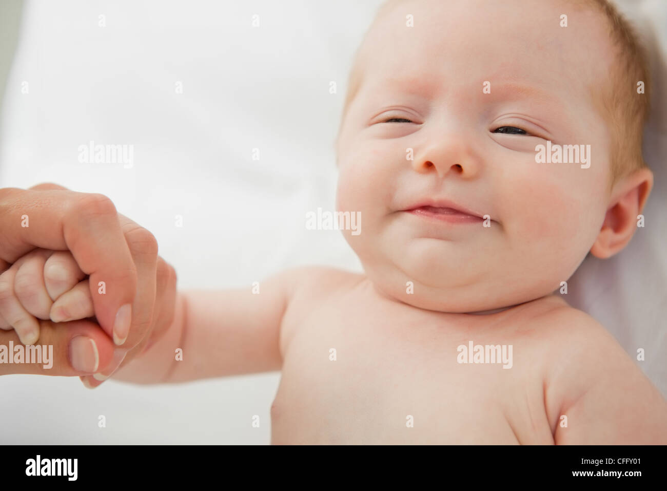 Baby holding mothers hand Stock Photo - Alamy