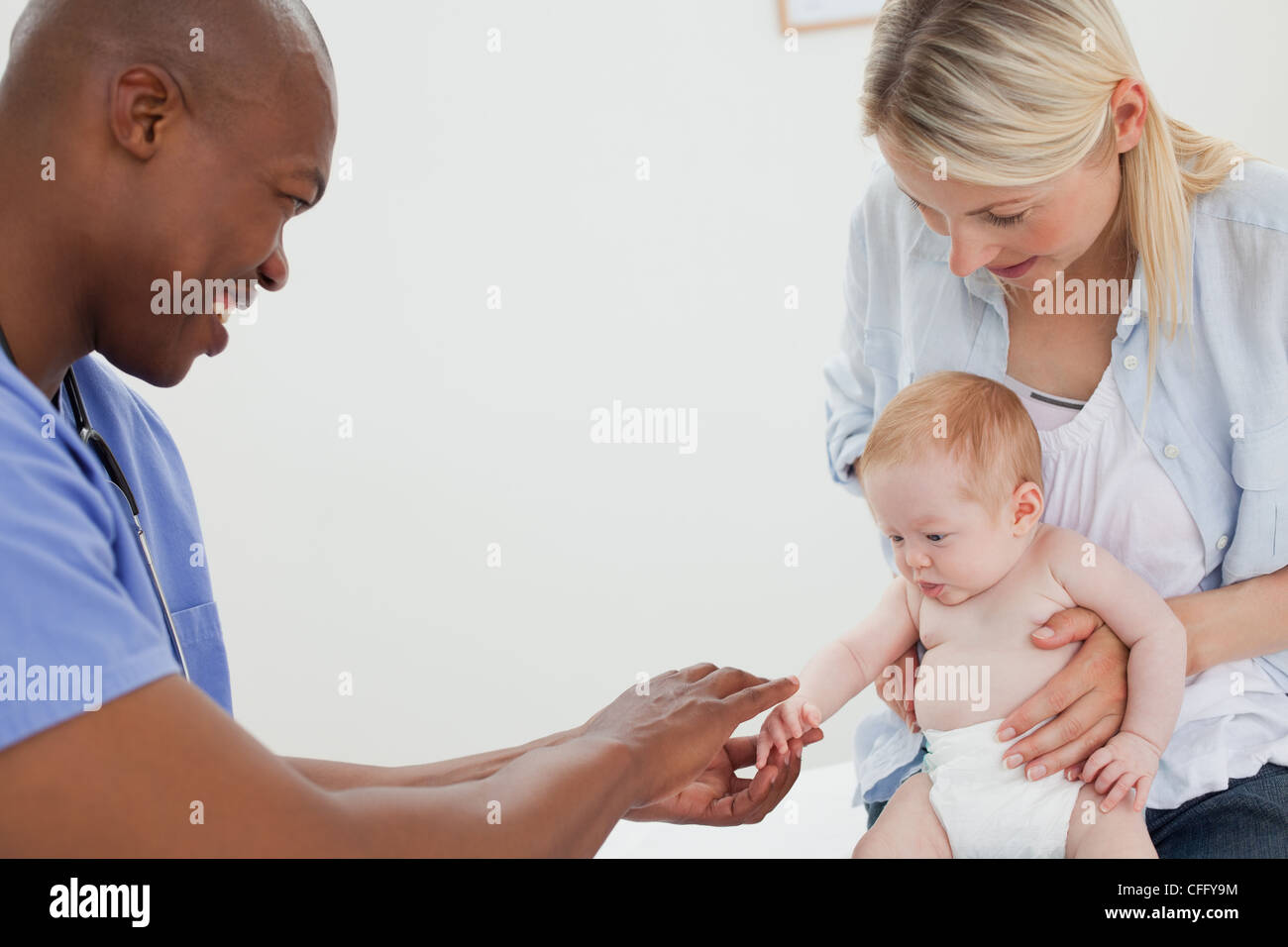 Doctor holding baby's hand Stock Photo - Alamy