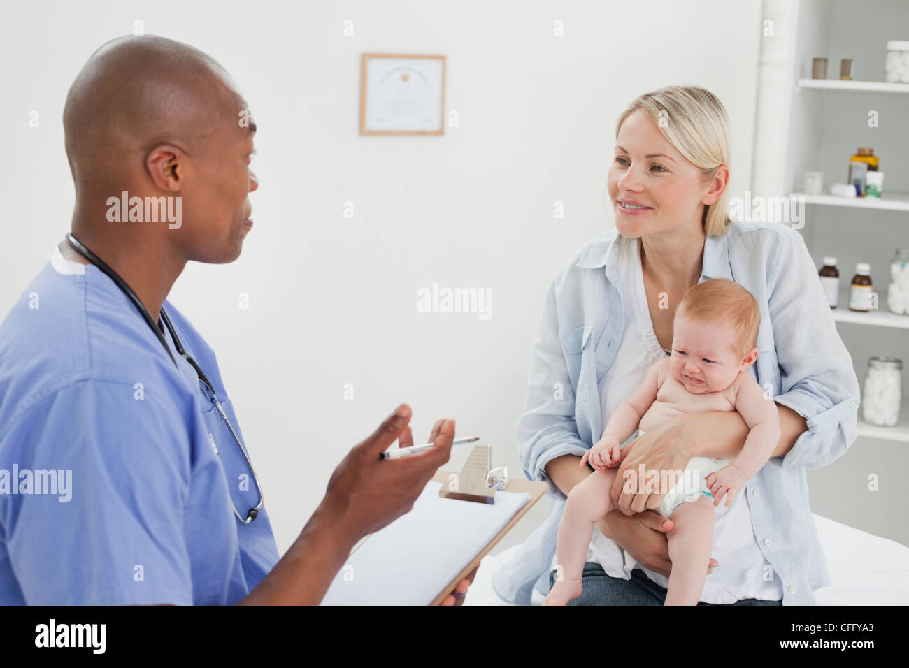 Doctor talking to the mother of his baby patient Stock Photo - Alamy