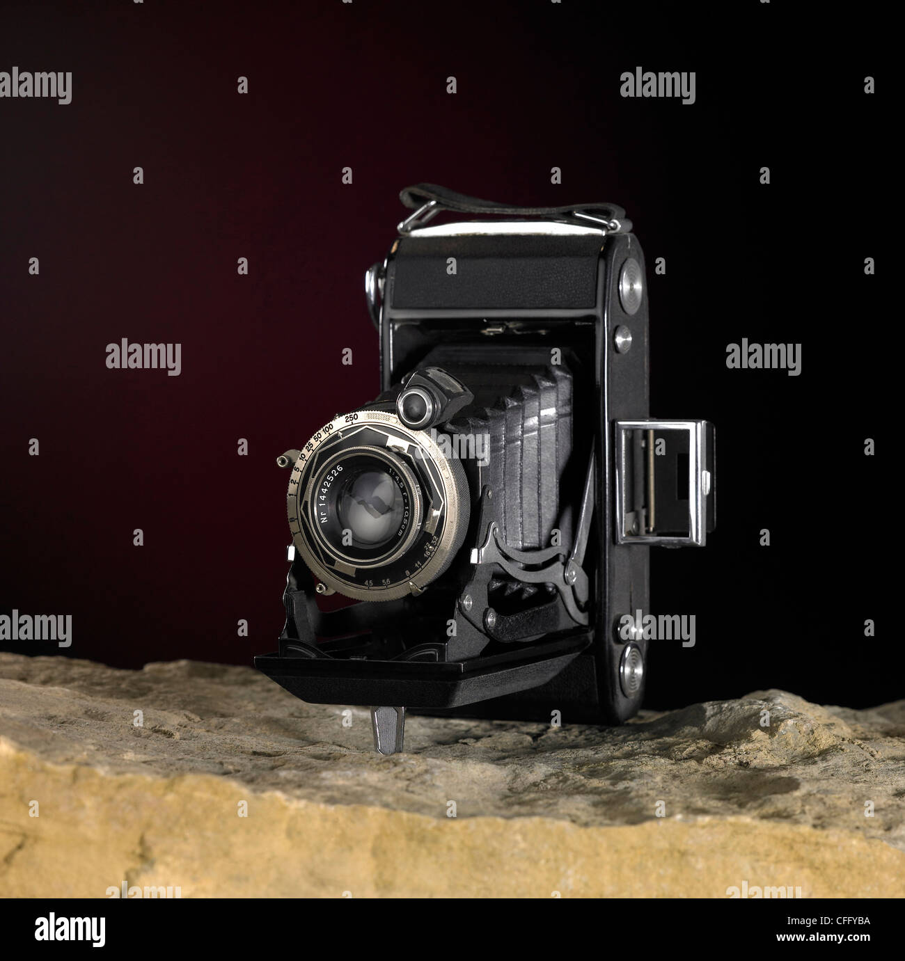 Still life with nostalgic camera on stone ground in front of dark back ...