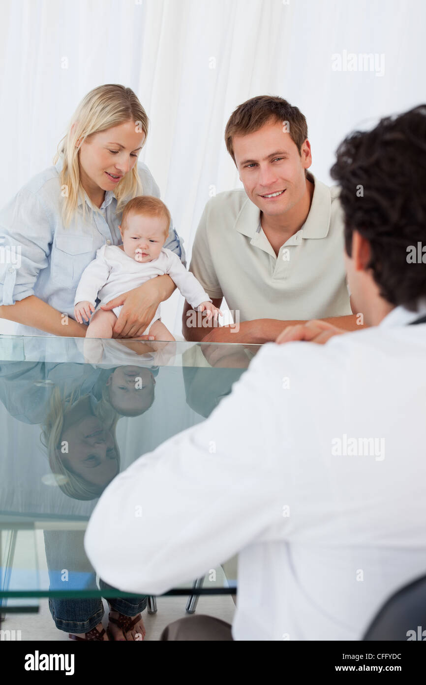 Doctor talking to young family Stock Photo - Alamy