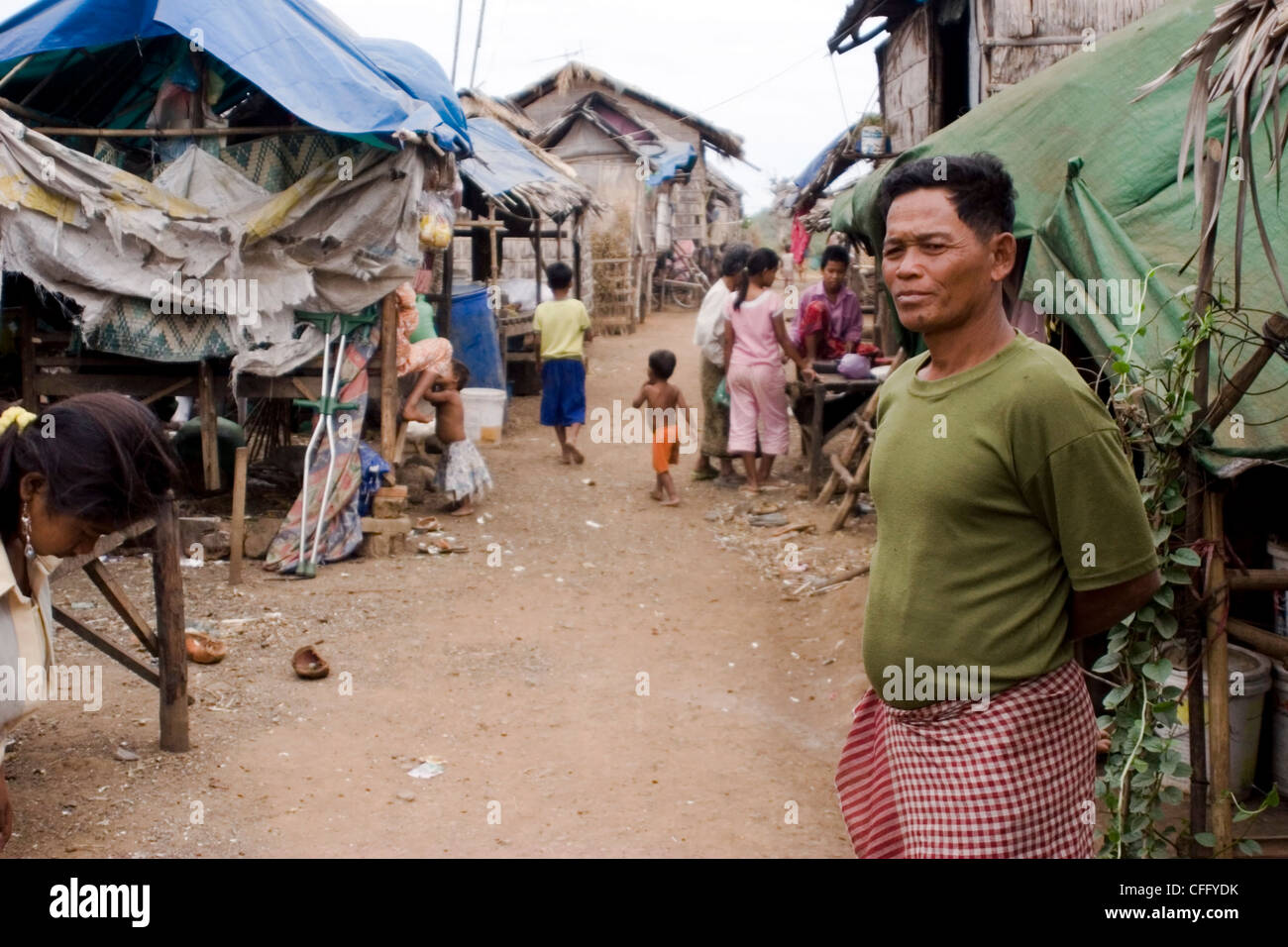 The village manager (right) is standing near his dilapidated home in a ...