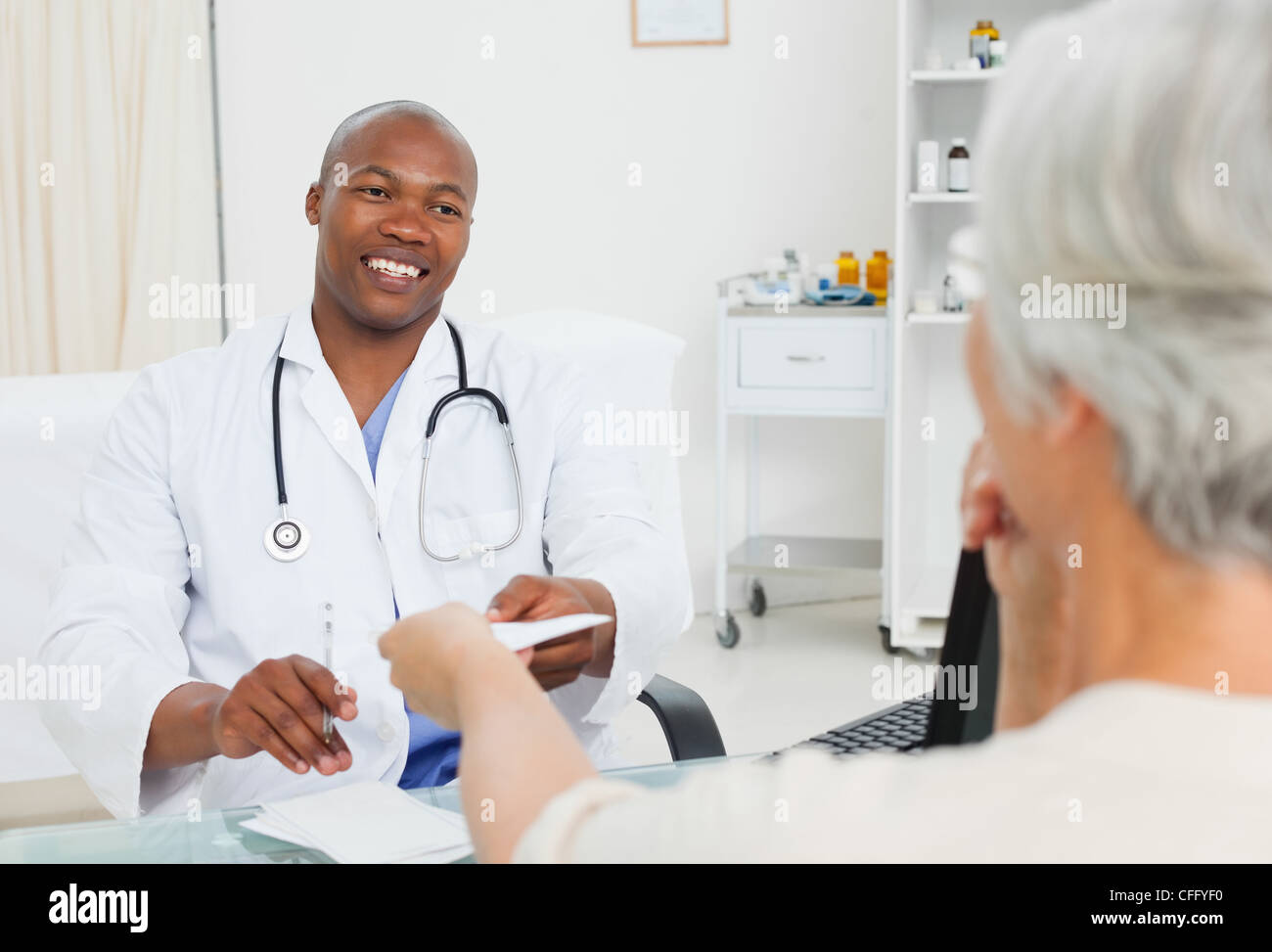 Smiling doctor giving his patient a prescription Stock Photo - Alamy