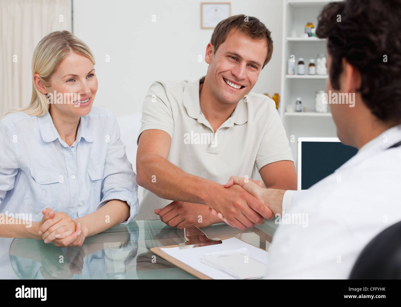 Happy couple greeting their doctor Stock Photo - Alamy