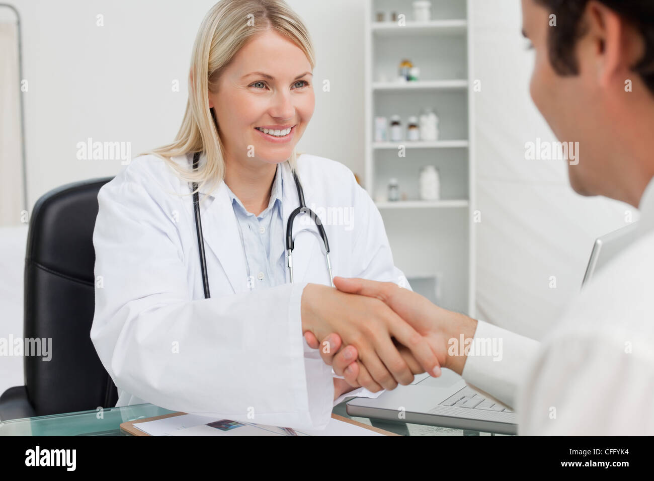 Smiling doctor greeting her patient Stock Photo - Alamy
