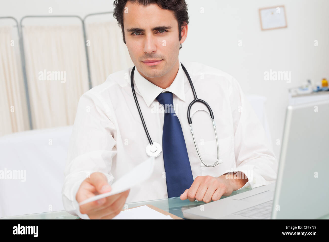 Serious doctor handing over a prescription Stock Photo - Alamy