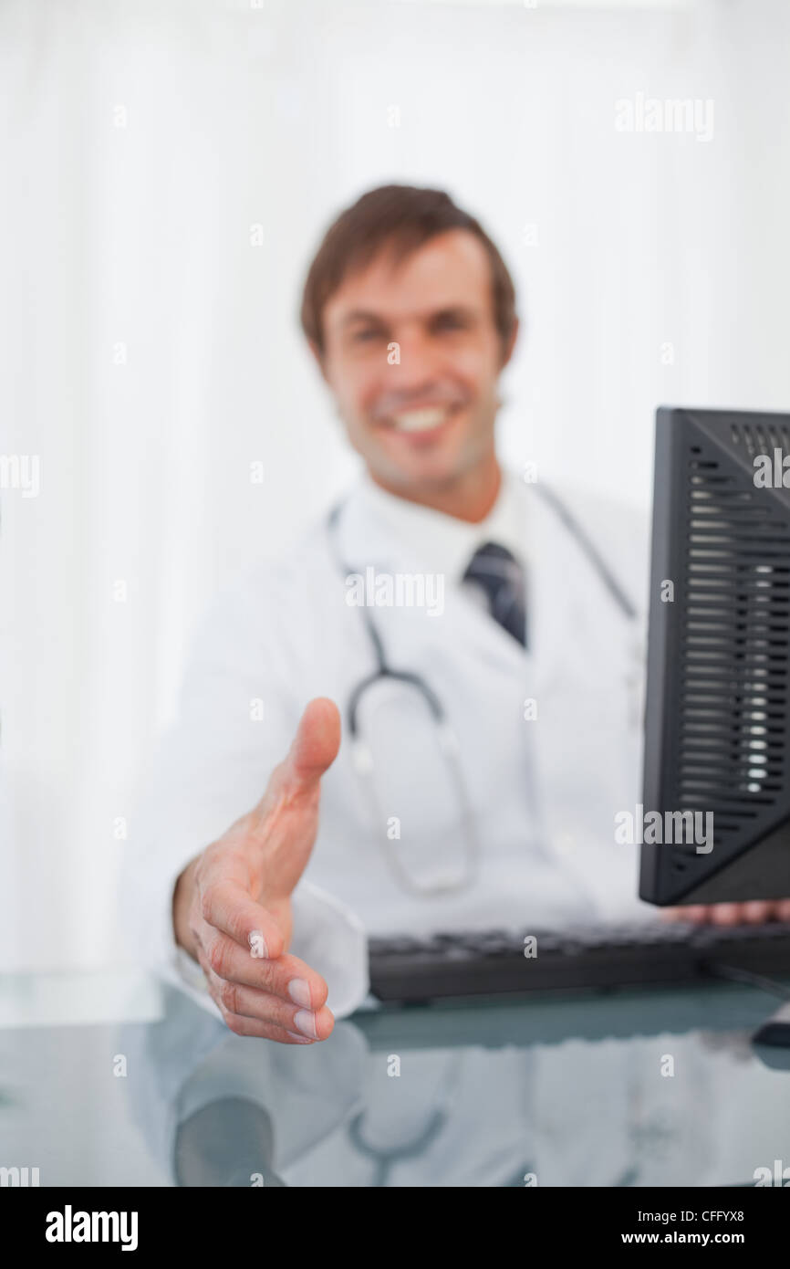 Smiling doctor with his hand held out for a handshake Stock Photo - Alamy