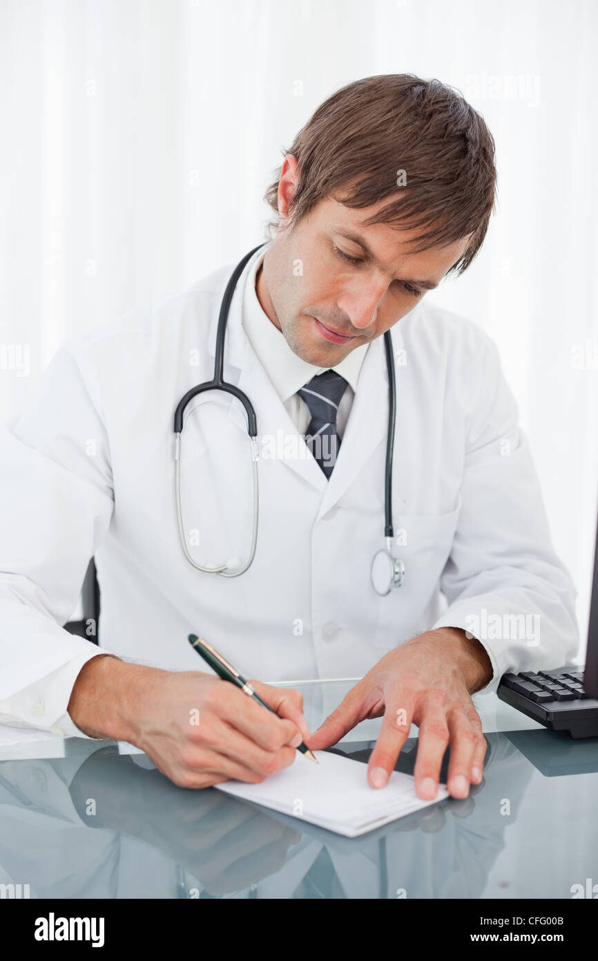 Serious doctor writing out a prescription Stock Photo - Alamy
