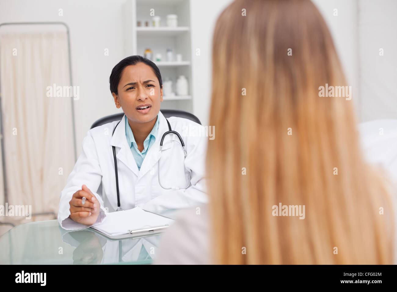 Serious practitioner talking to her patient Stock Photo - Alamy