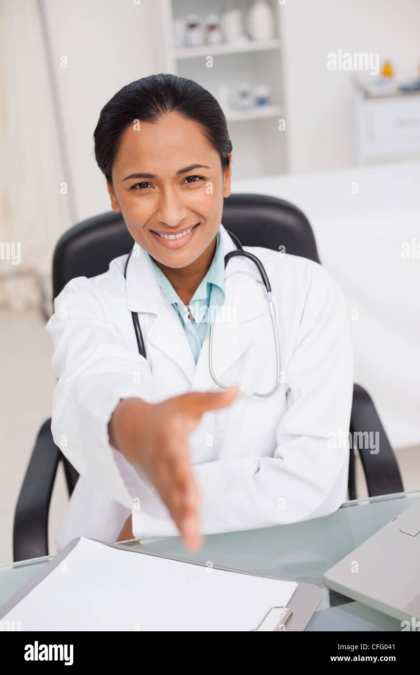 Smiling doctor offering her hand out for a handshake Stock Photo - Alamy