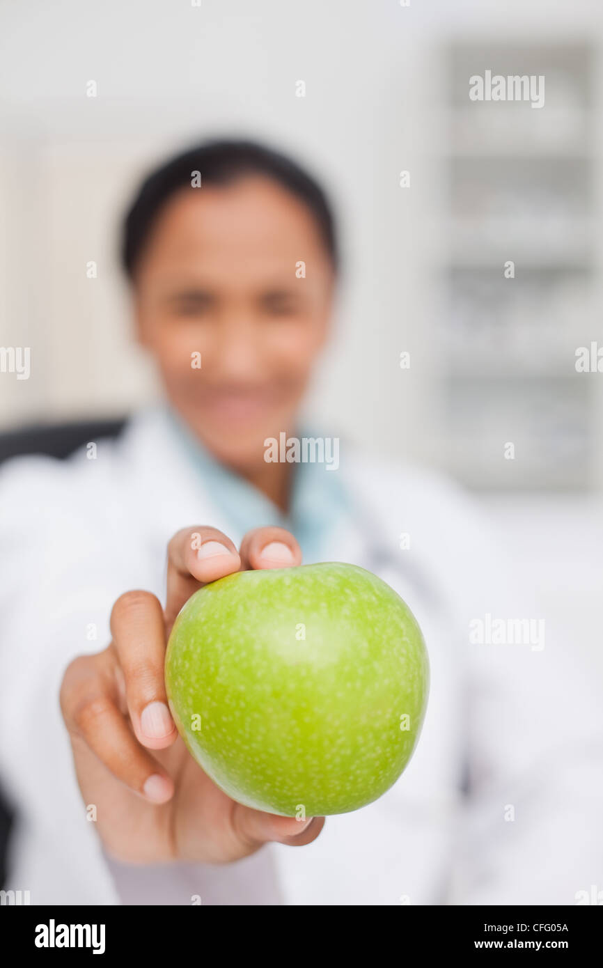 Big green apple being held by a doctor Stock Photo - Alamy