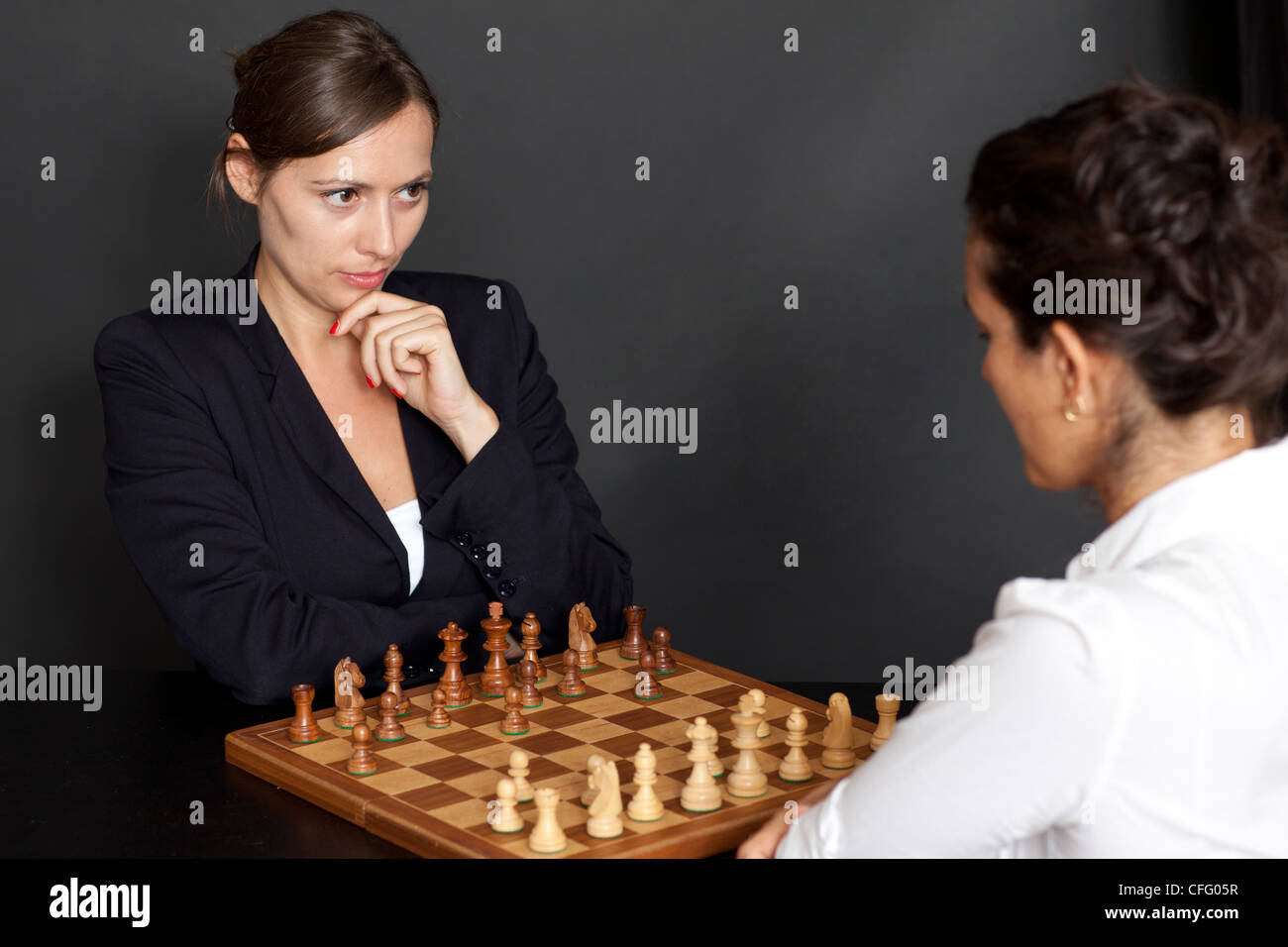 Two business women play chess and think about strategy Stock Photo - Alamy