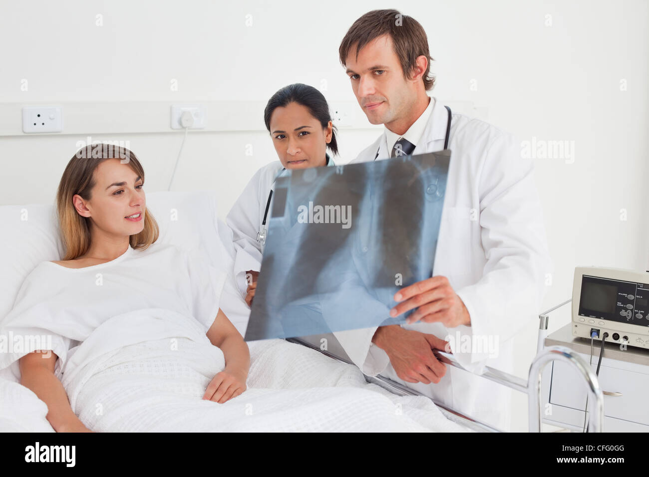 Doctors showing an x-ray to a patient Stock Photo - Alamy