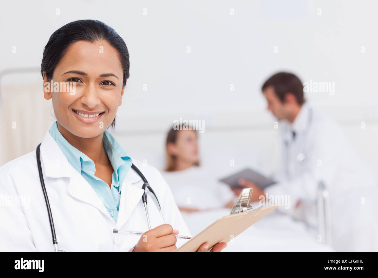 Smiling surgeon holding a clipboard while standing in front of a ...