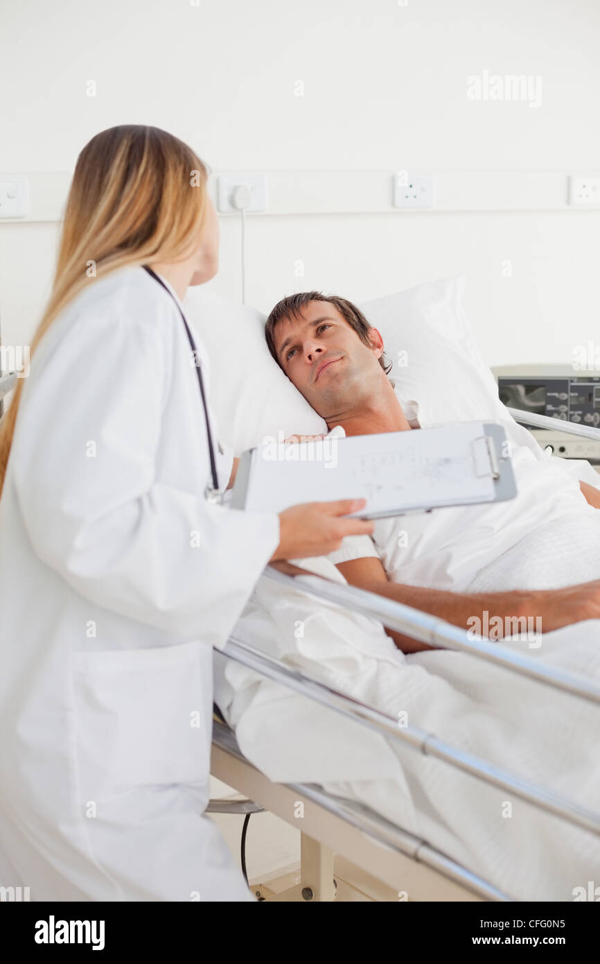 Peaceful patient looking at his doctor who is holding a clipboard Stock ...