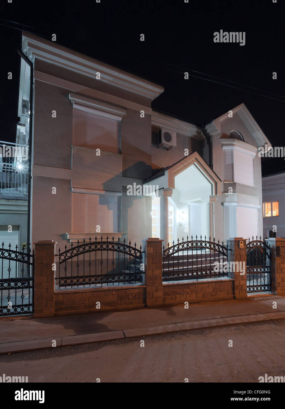 Exterior of a big grey house by night Stock Photo - Alamy