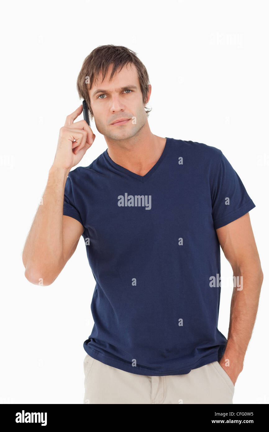 Serious man talking on the phone while looking at the camera Stock ...