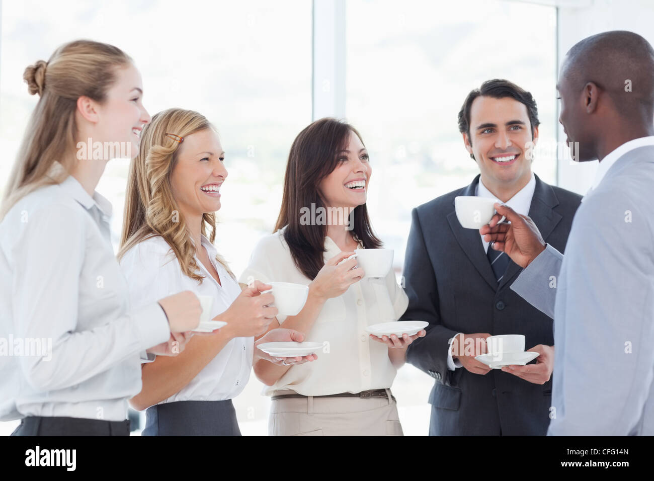 Five friends laughing while drinking tea Stock Photo - Alamy