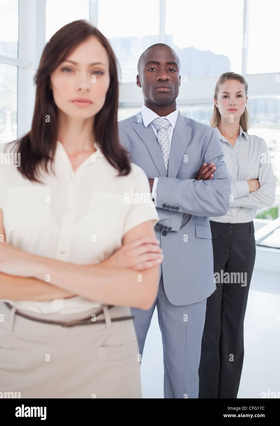 Two colleagues standing behind their co-worker Stock Photo - Alamy