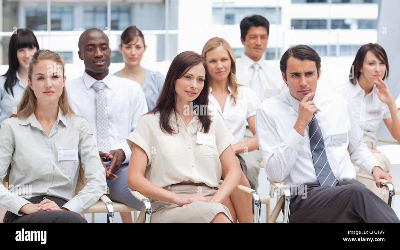 Colleagues looking ahead as they sit together Stock Photo - Alamy