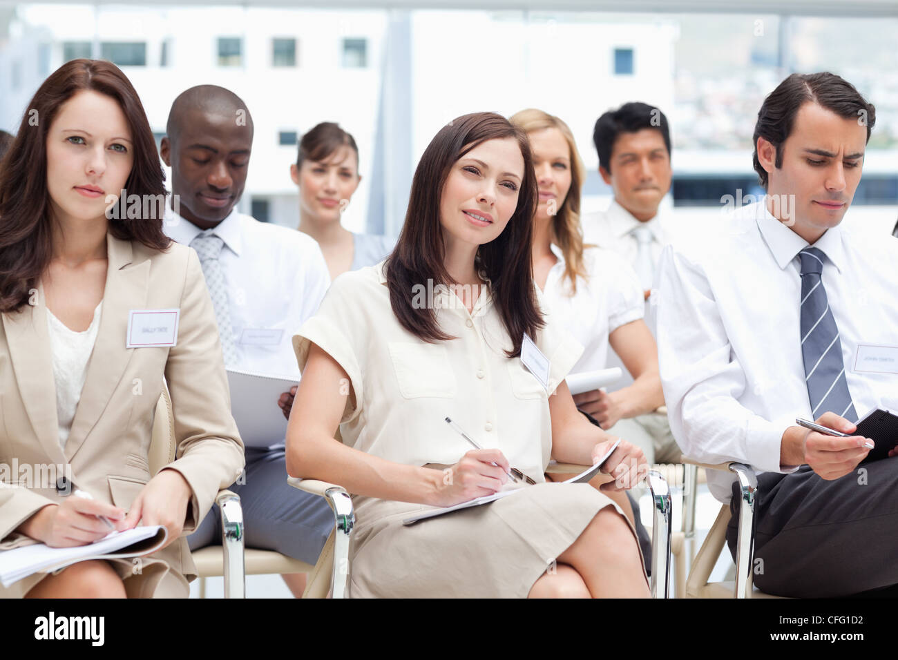 Colleagues writing notes as they sit together Stock Photo - Alamy