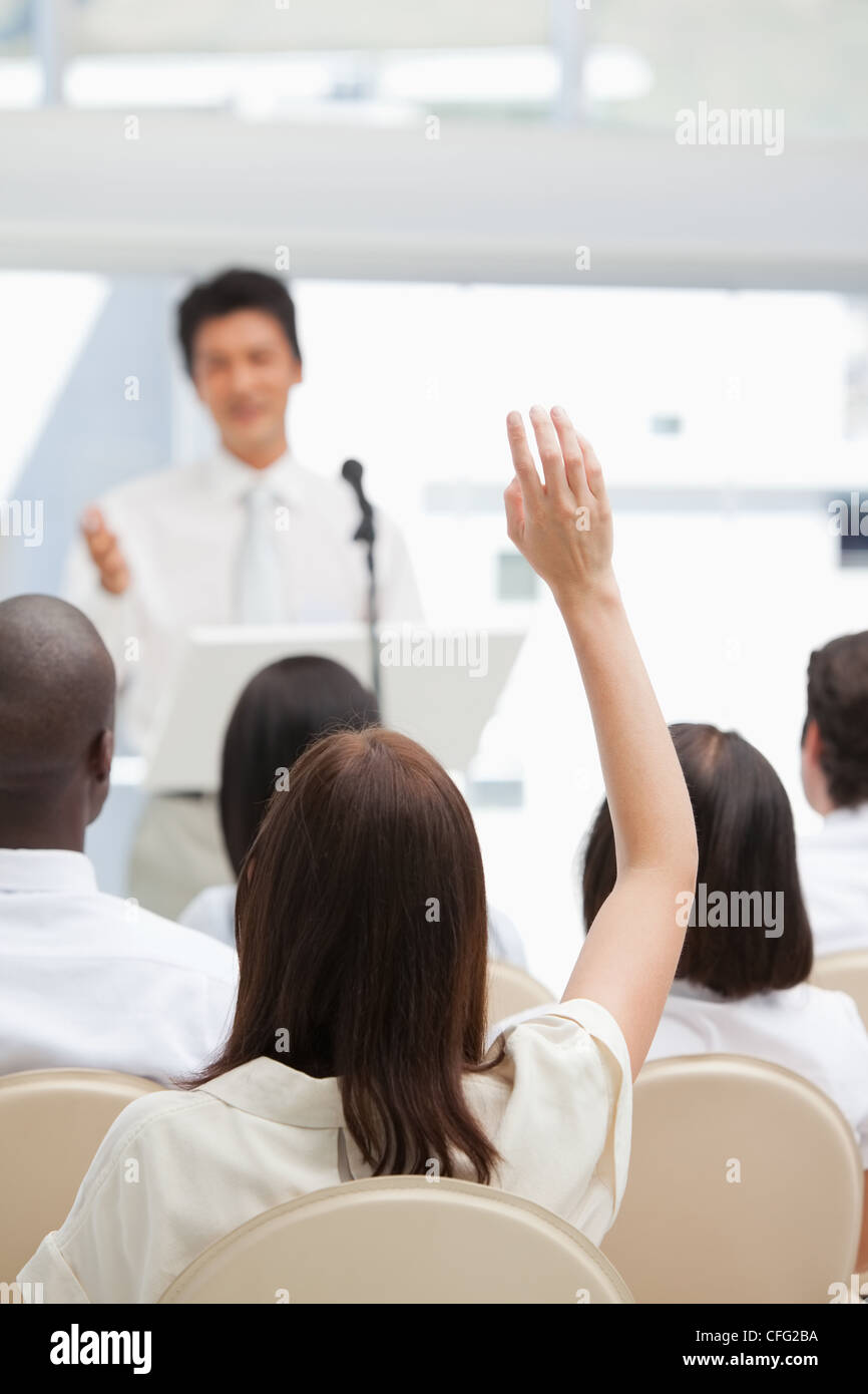 Woman raising her hand while a businessman gestures towards her Stock ...