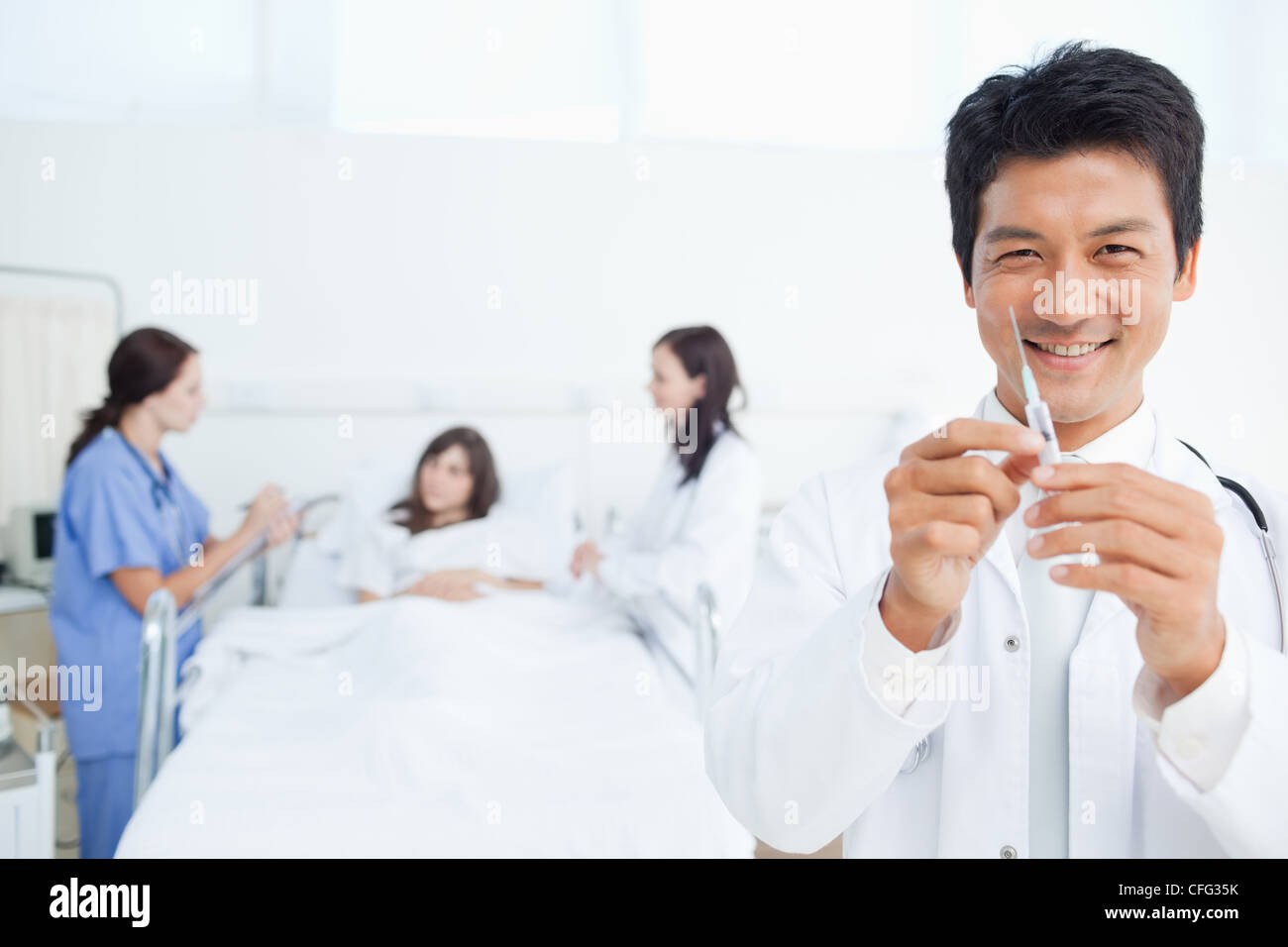 Serious doctor looking ahead as he prepares a syringe Stock Photo - Alamy