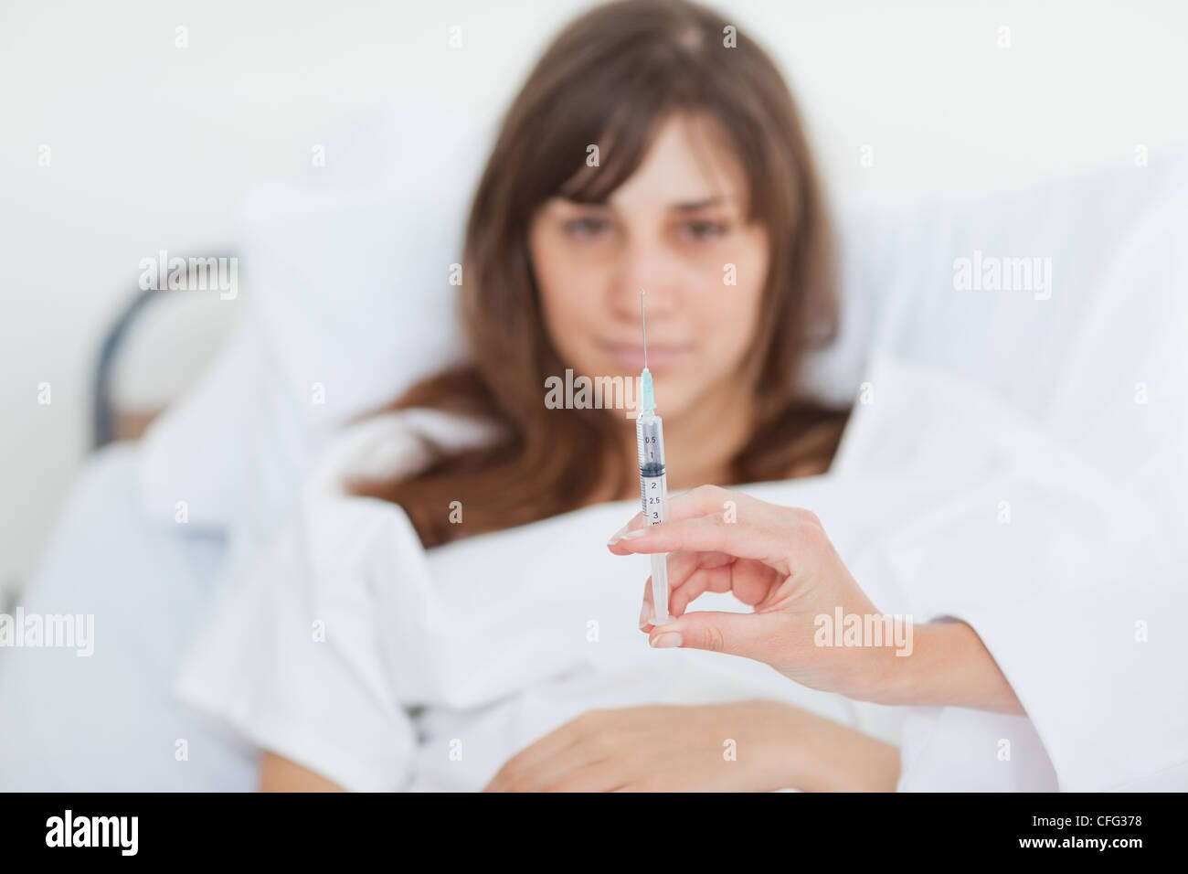 Syringe being held in front of a patient Stock Photo - Alamy