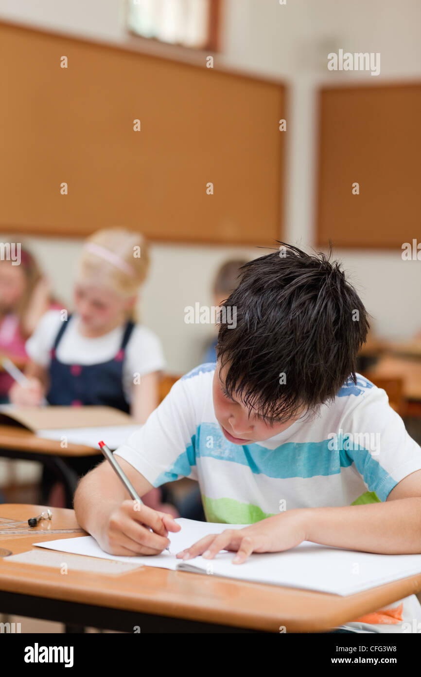 Primary student working focused on exercise book Stock Photo - Alamy