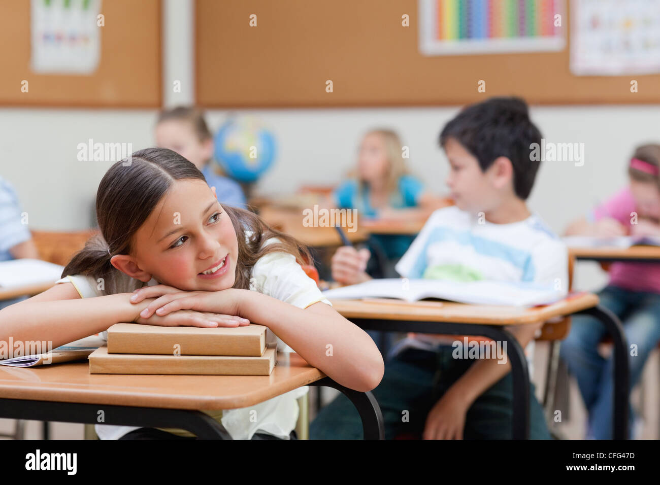 Student daydreaming on a pile of books Stock Photo - Alamy
