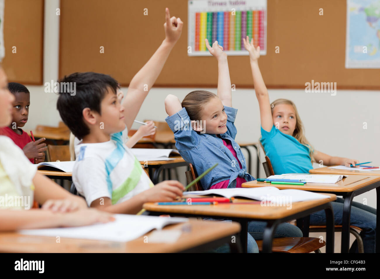 Side view of students raising hands Stock Photo - Alamy