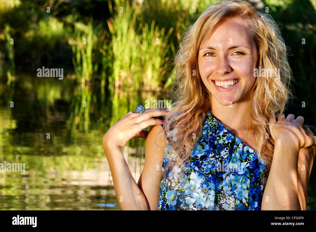 View of a beautiful young girl with a blue dress on the stream of a ...