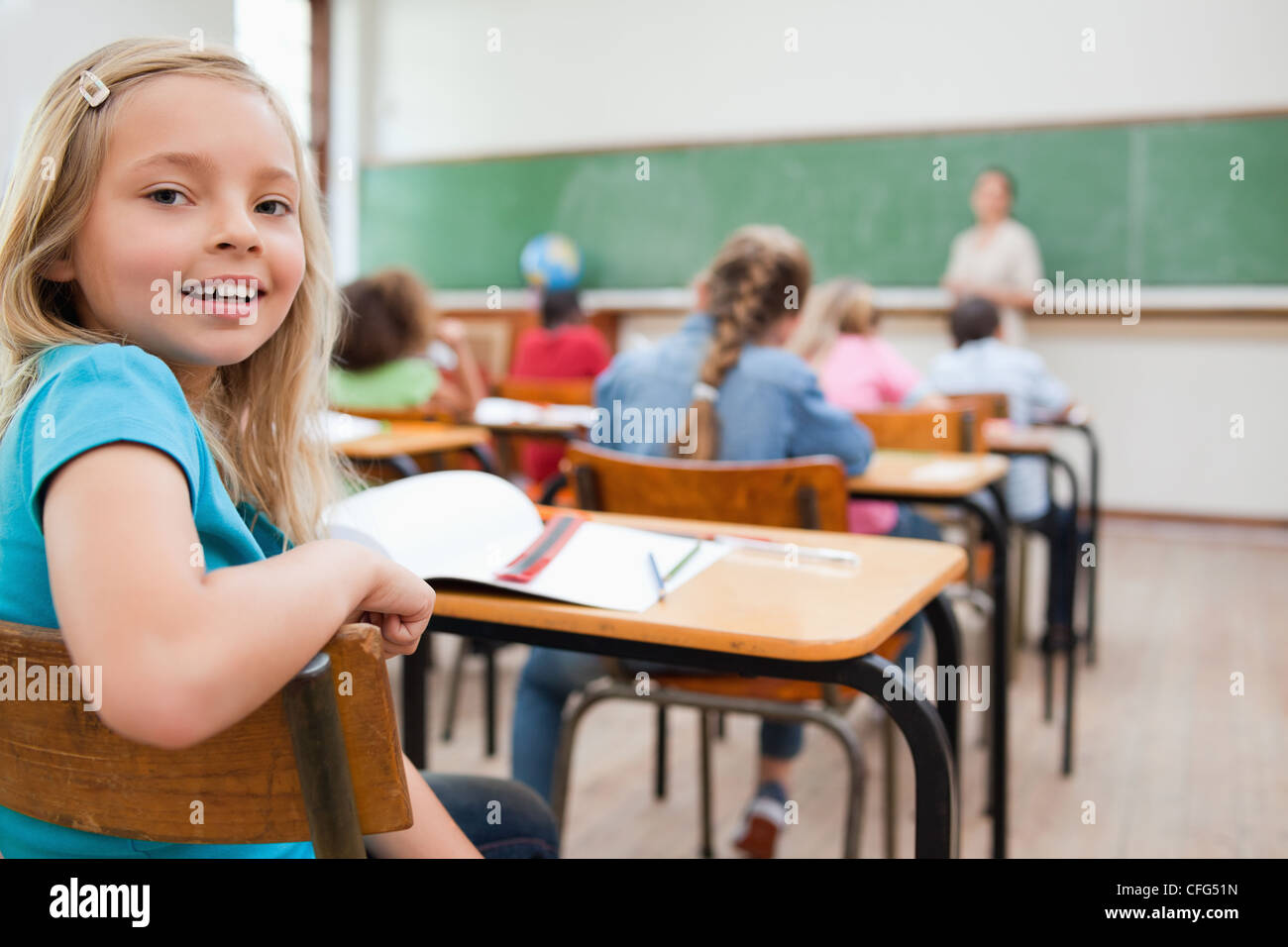 Smiling student turning around during class Stock Photo - Alamy