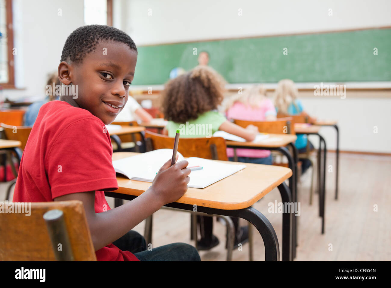 Schoolboy turning around in class Stock Photo - Alamy