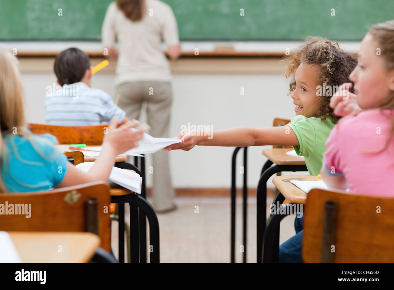 Girl handing over sheets Stock Photo - Alamy