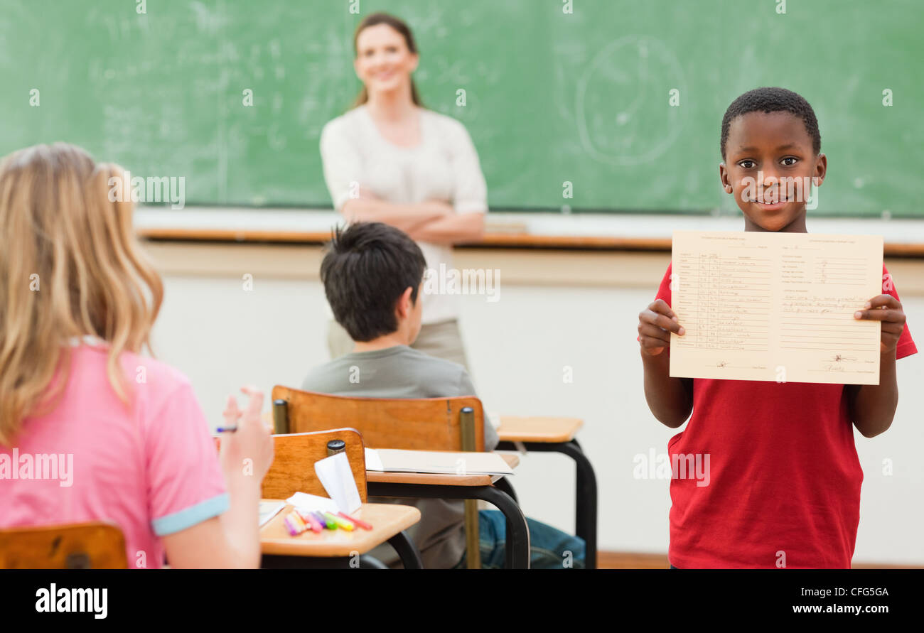 Smiling schoolboy showing his report card Stock Photo - Alamy