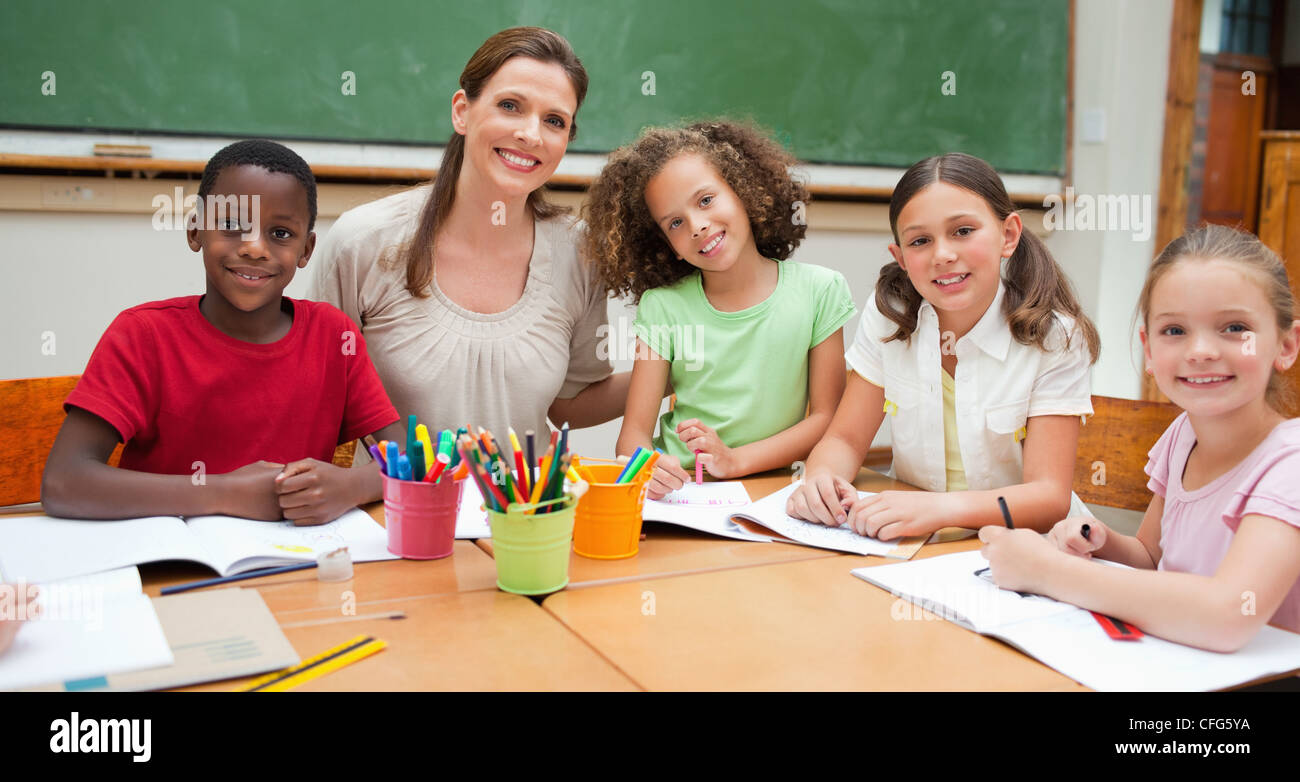 Smiling teacher with her students during art class Stock Photo - Alamy