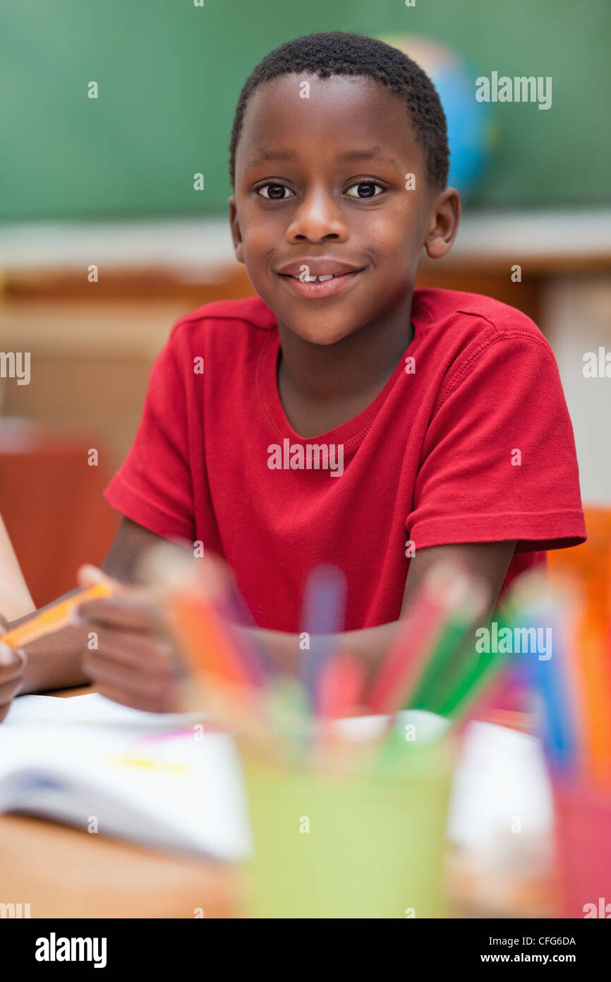 Smiling student sitting at desk during class Stock Photo - Alamy