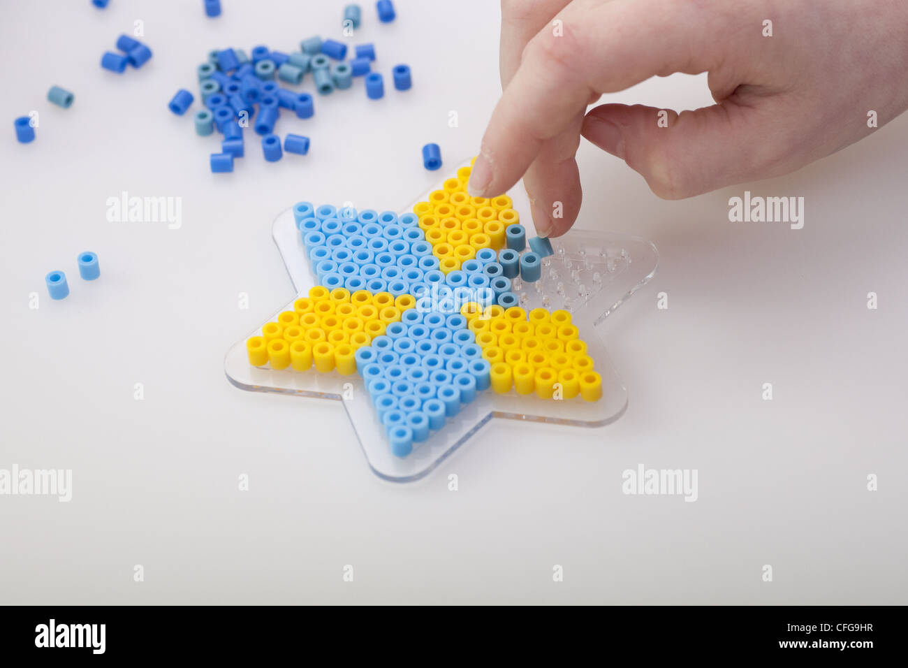 Little blond girl playing with Hama beads Stock Photo - Alamy