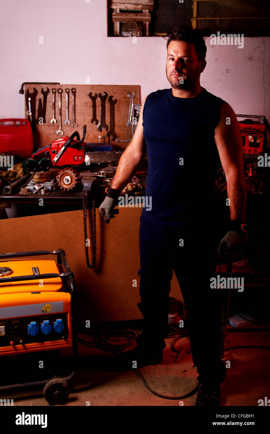 View of a mechanic man inside a garage with many tools Stock Photo - Alamy