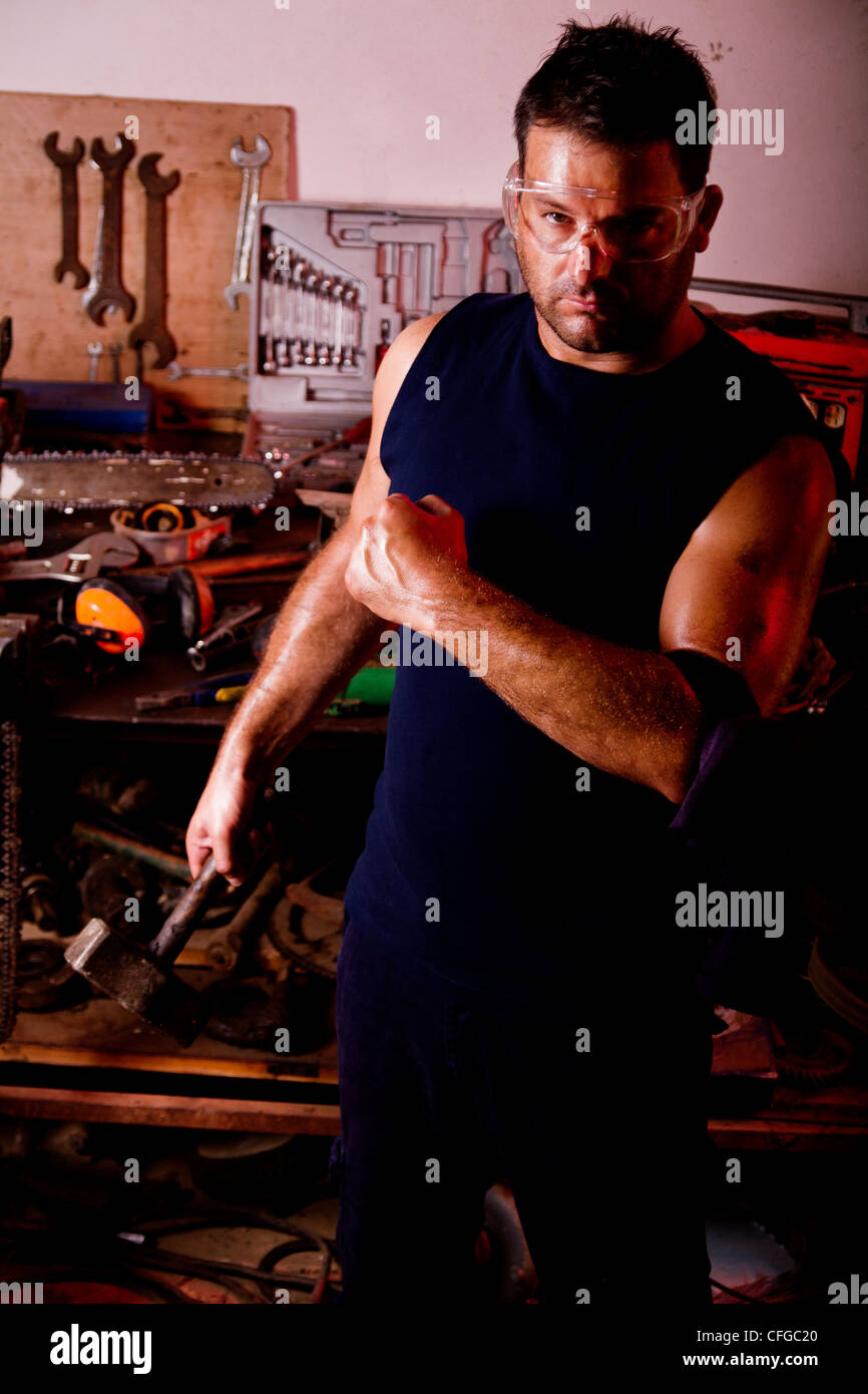 View of a garage mechanic man holding a hammer Stock Photo - Alamy