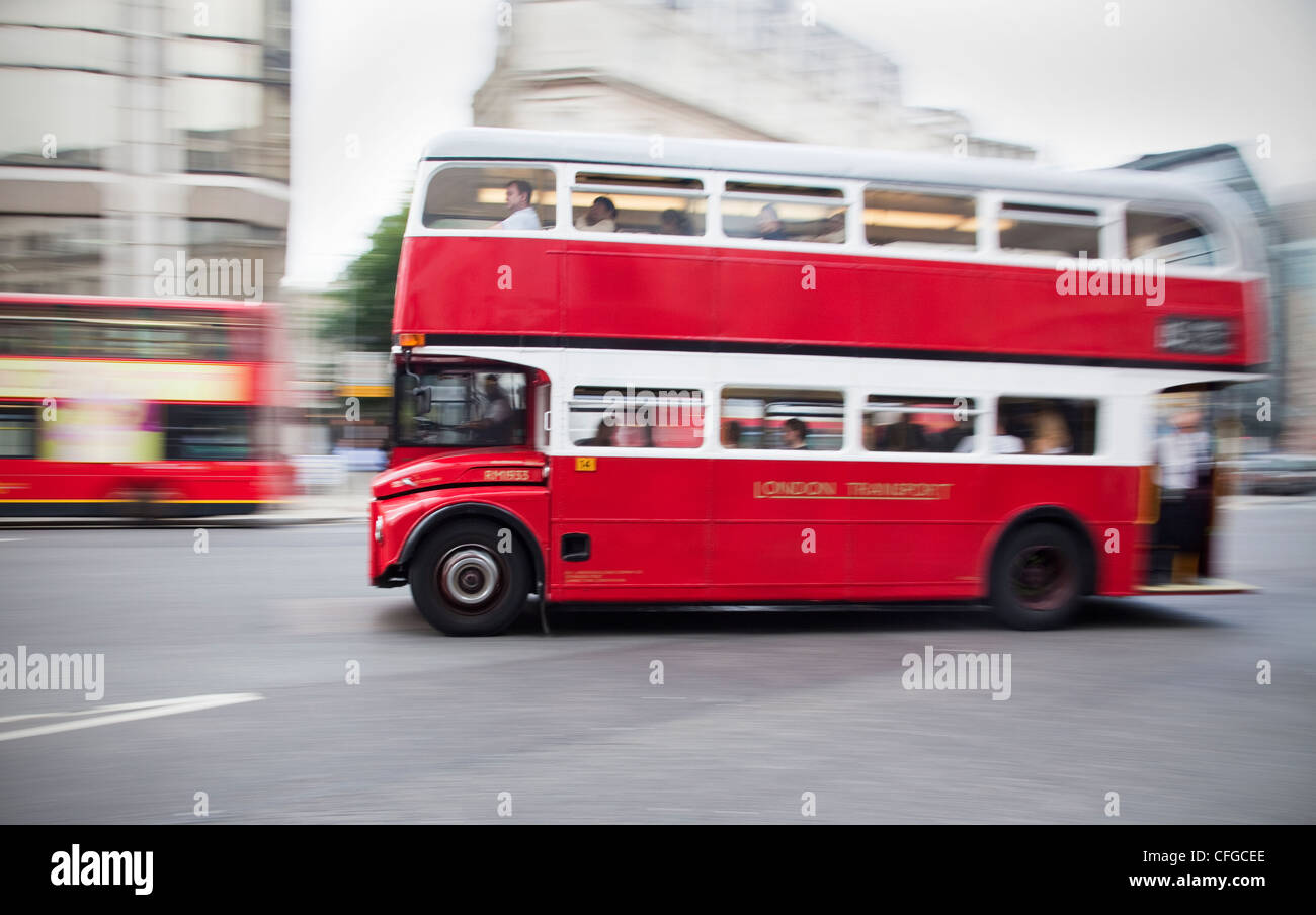 Iconic red London bus speeding through the city Stock Photo - Alamy