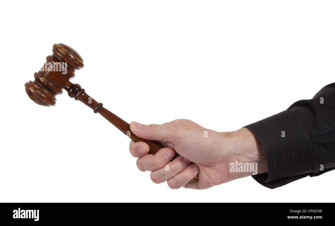 A hand holding a brown gavel on a white background Stock Photo - Alamy