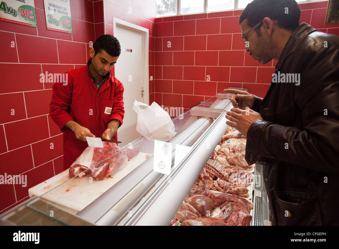 A butcher serves a customer Halal meat at a Halal supermarket in Nantes ...