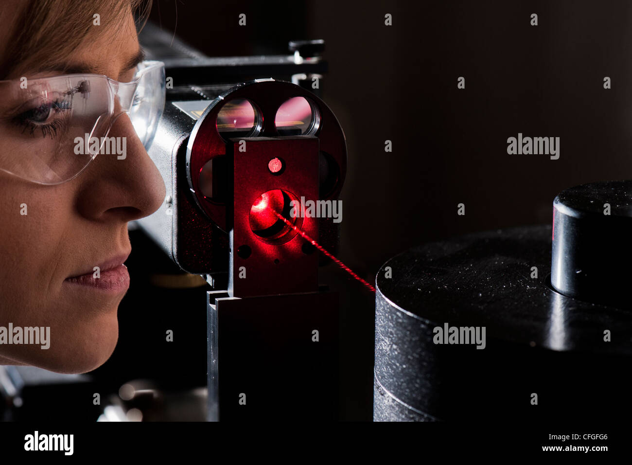Female lab worker in front of laser metering equipment Stock Photo - Alamy