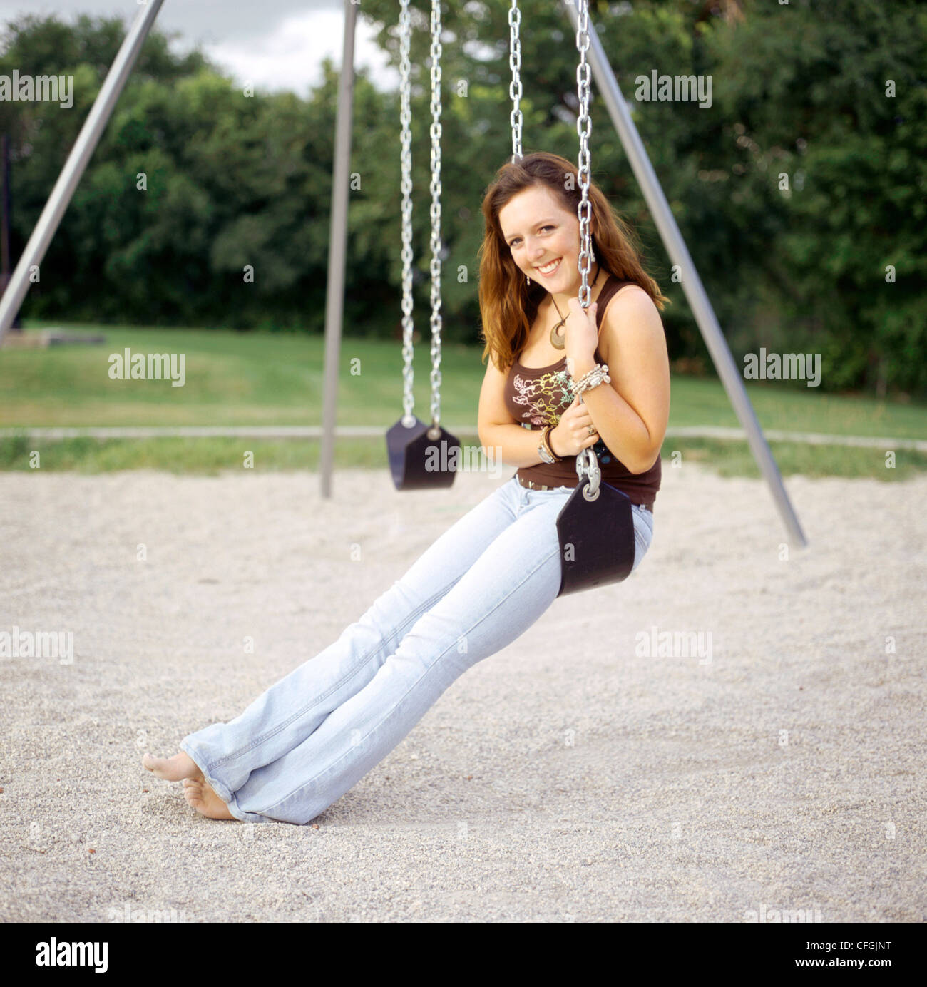 Young Woman sitting on Swing Stock Photo - Alamy